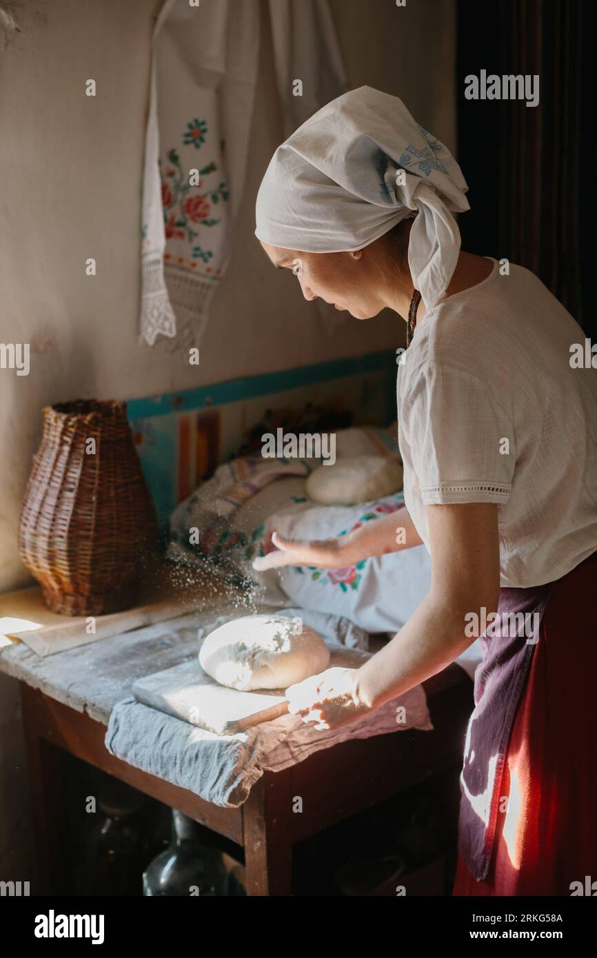 The process of traditional baking of bread at home. A woman in national ...