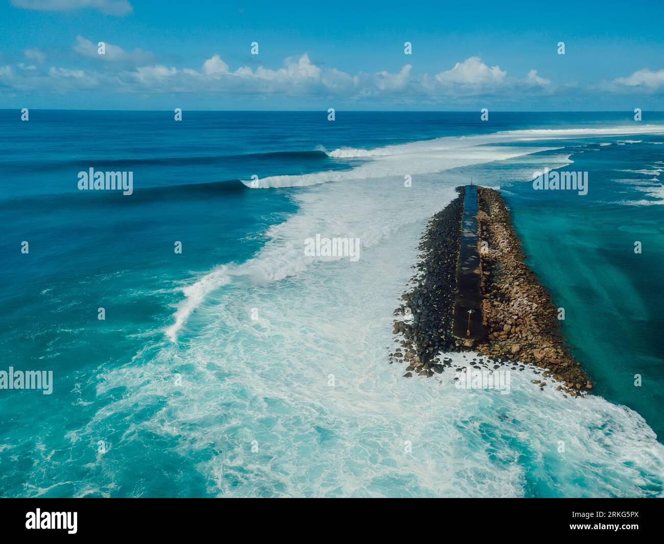 Perfect long waves with barrels and breakwater in ocean. Aerial view ...