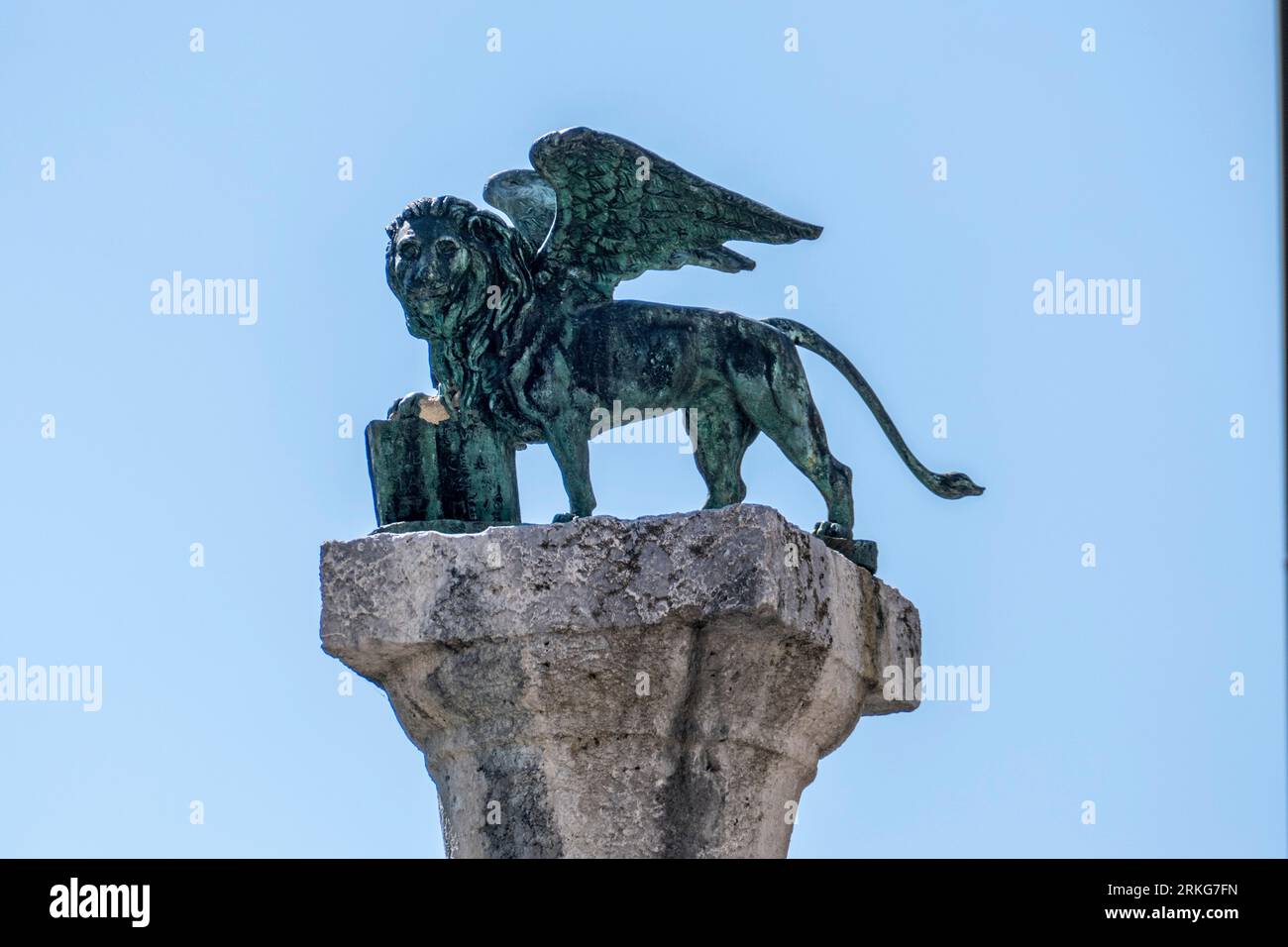 An imposing lion statue crafted from a vibrant green material perches ...