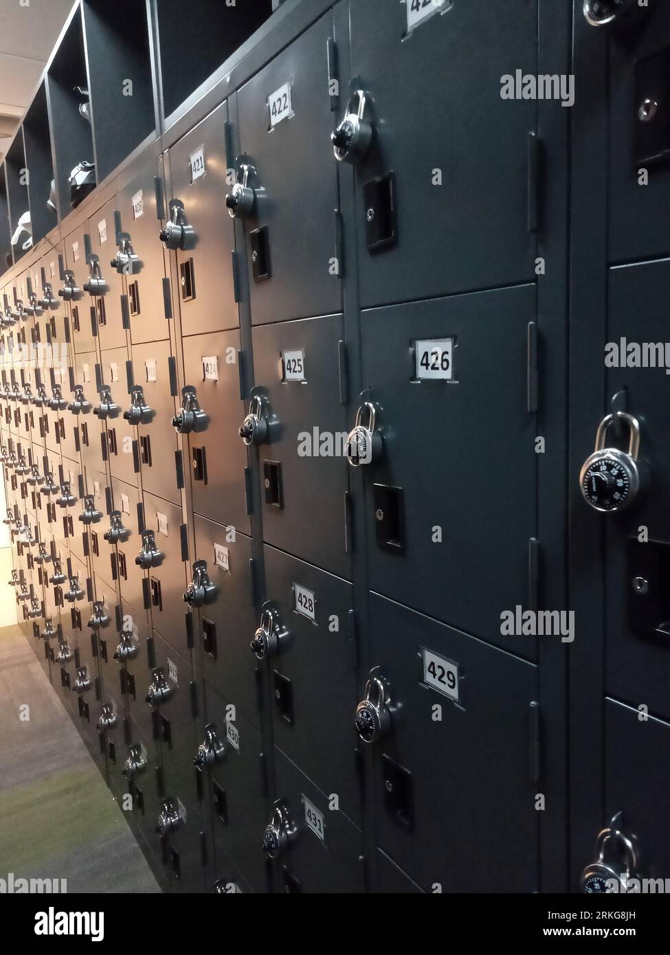 A row of silver metal lockers with padlock latches and handles in an ...