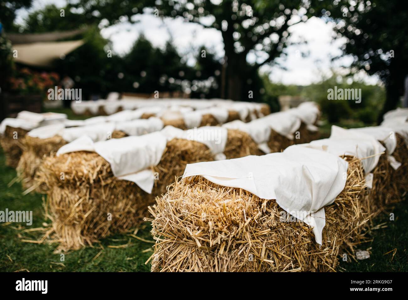 A stacked pile of hay bales wrapped in white paper, creating a rustic ...