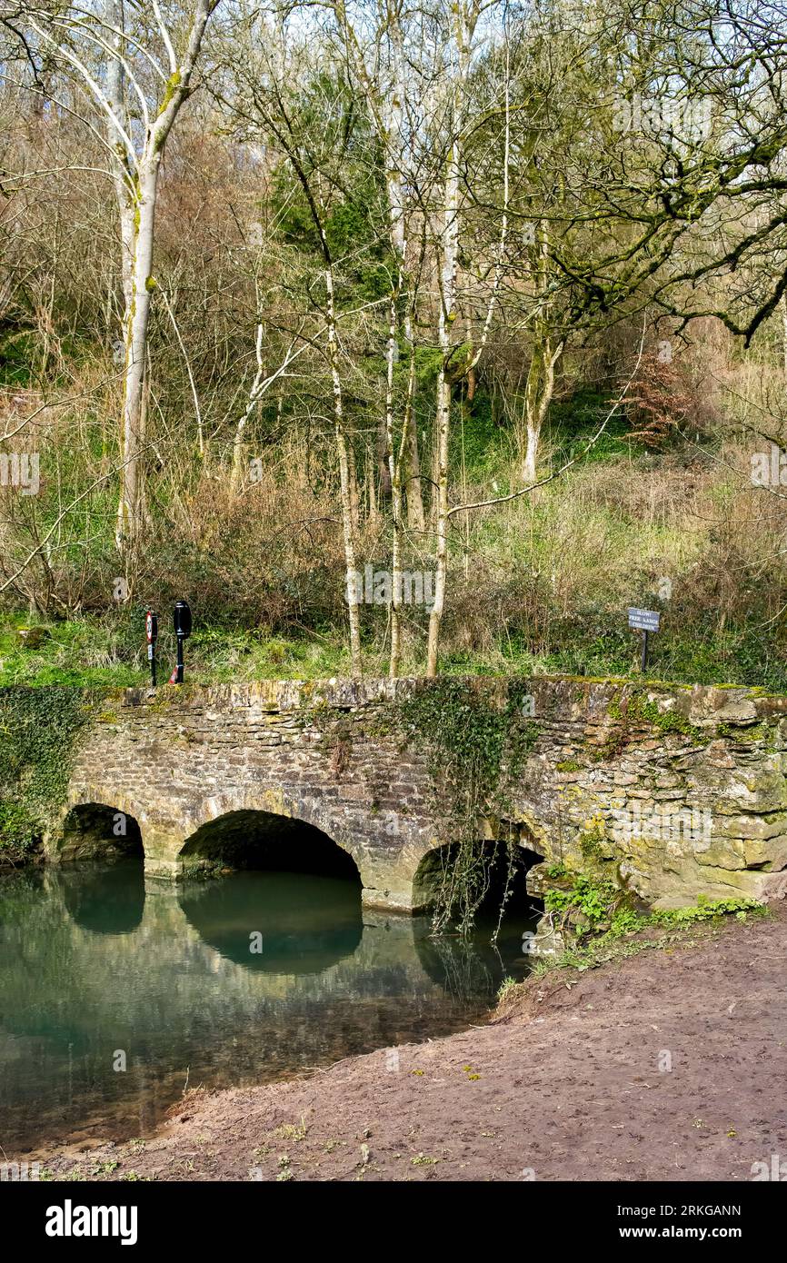 ByBrook River and stone bridge at Castle Combe village in the Cotswolds ...