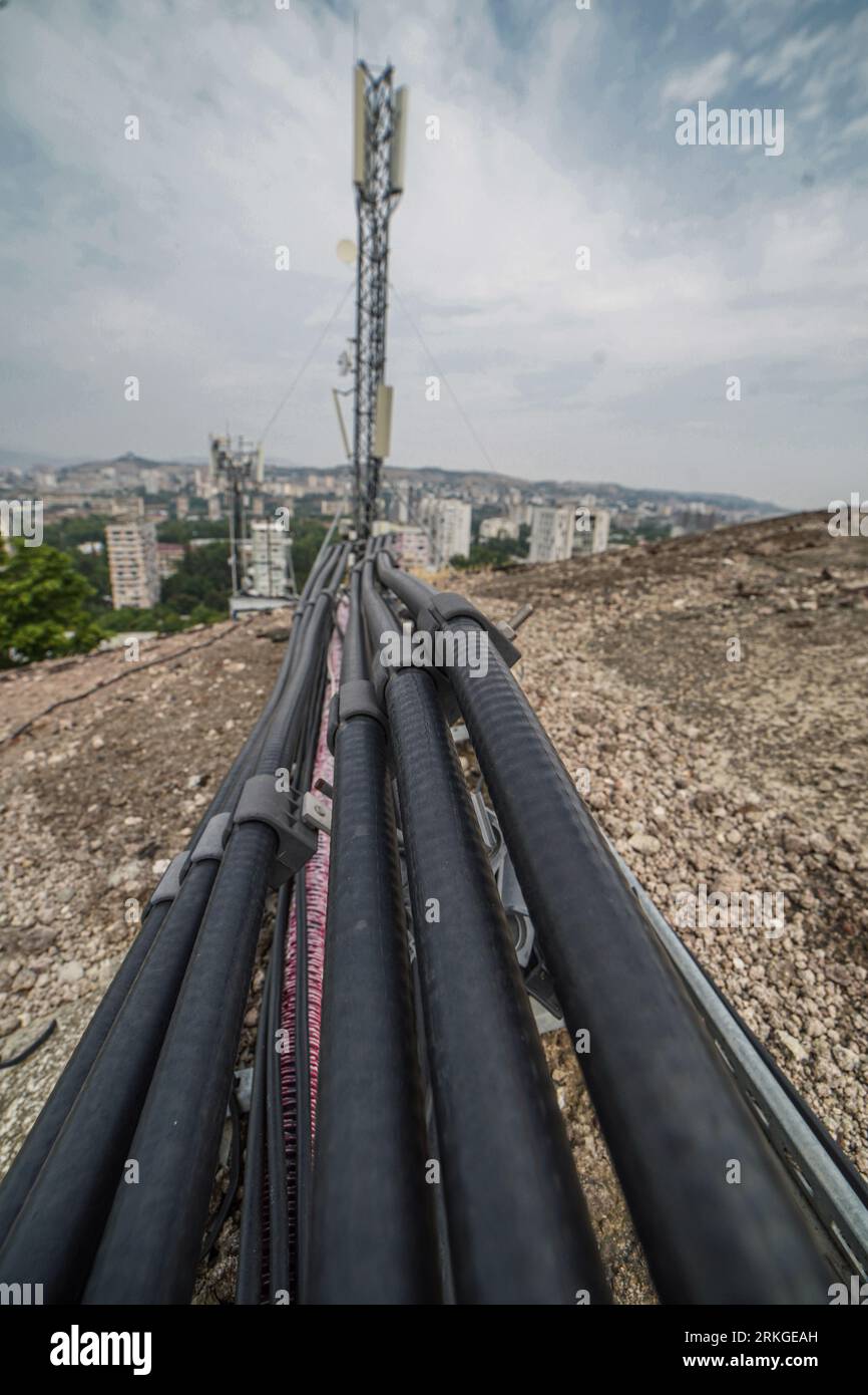 A large, organized stack of pipes atop a hill connecting to a power ...