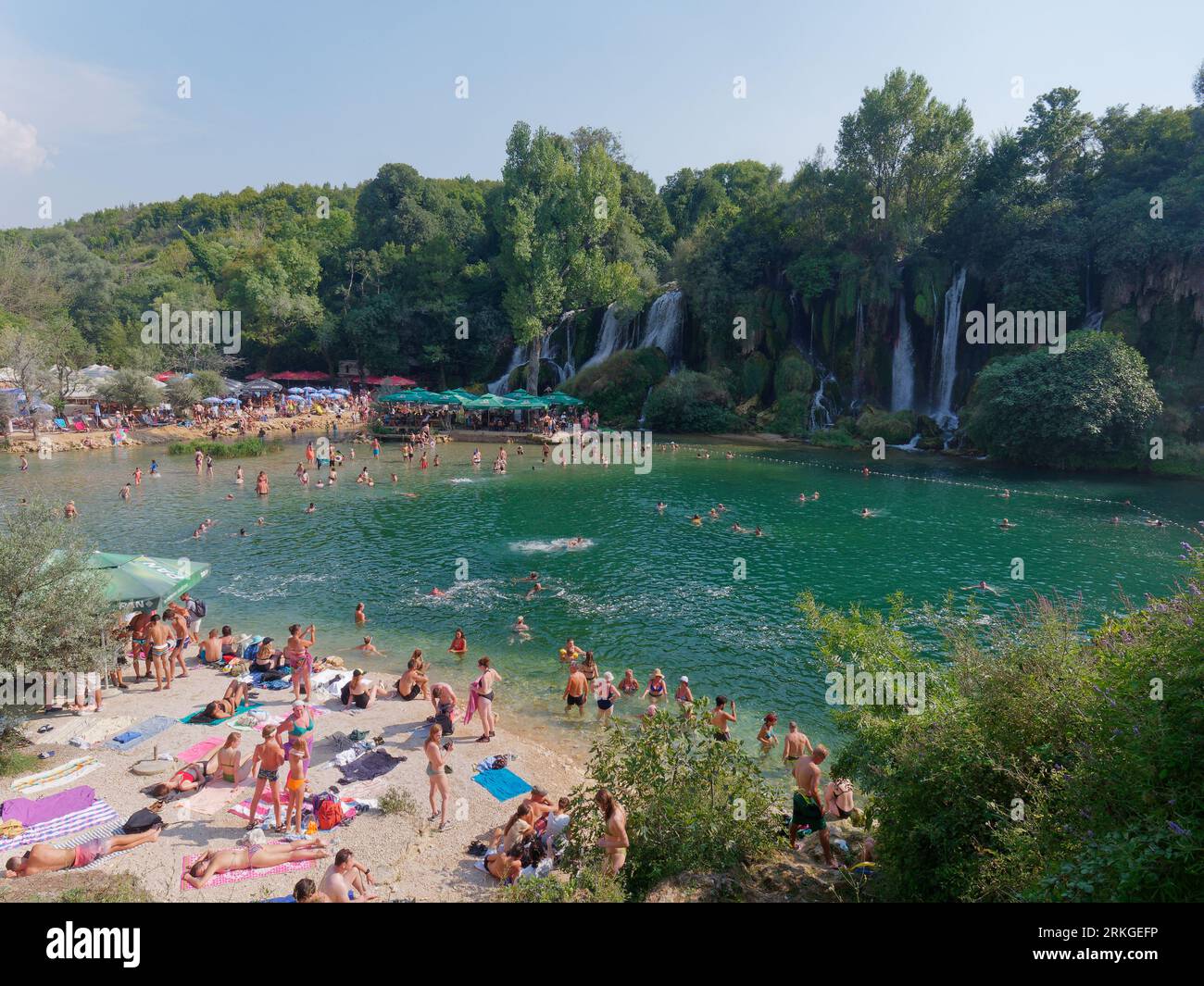 People enjoy beach area on Kravica Waterfall on the Trebižat River, in ...