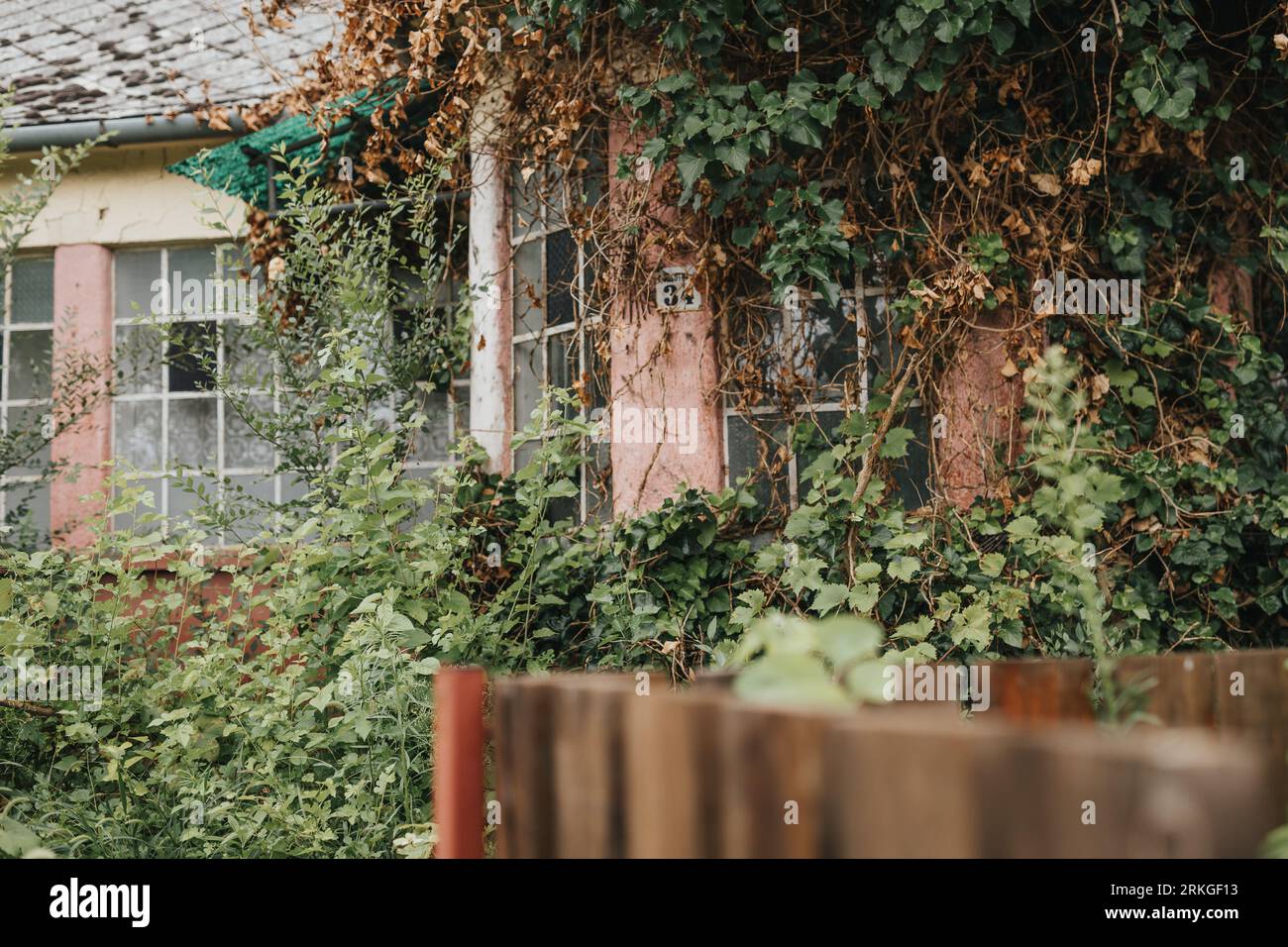 A rustic wooden fence lines the path to an aged two-story home, adorned ...