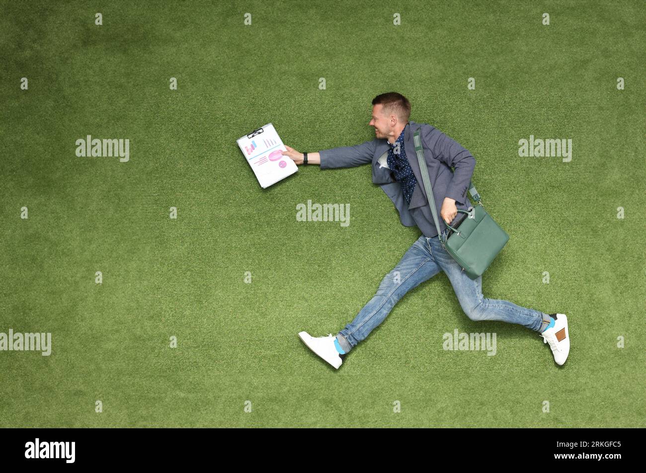 Young businessman happily running with work papers Stock Photo - Alamy
