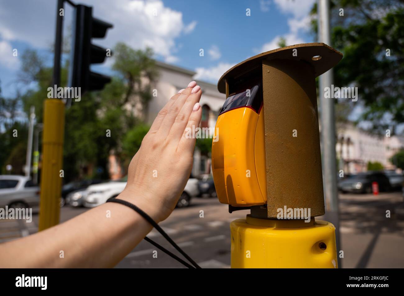 Close-up of a blind woman's hand pressing a button for a traffic light ...