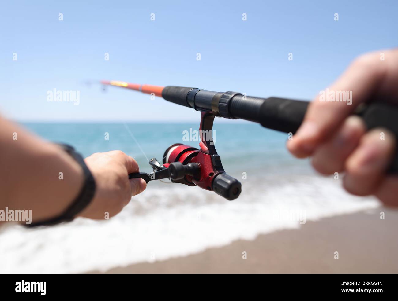 Man is fishing with line on seashore closeup Stock Photo - Alamy
