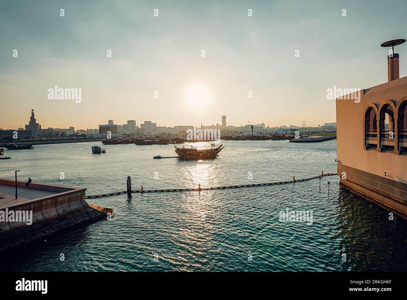 A scenic view of a boat sailing in a canal at golden hour in Doha ...