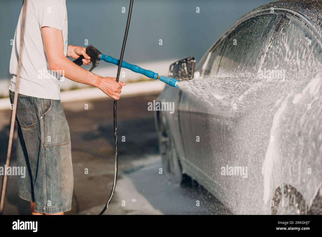 Worker washing car at self-service car wash Stock Photo - Alamy