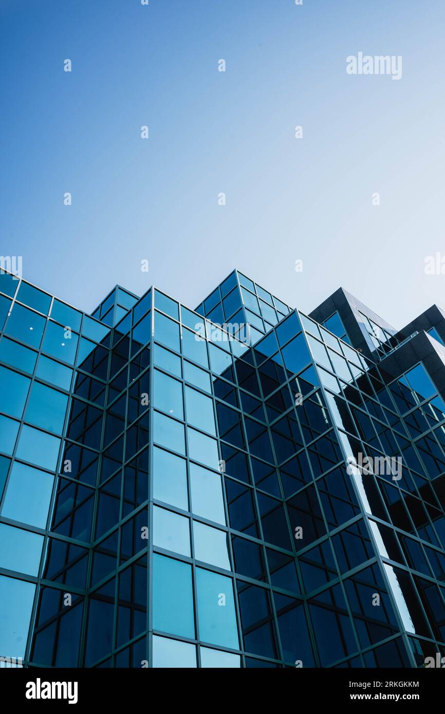 A high-rise glass office building with a modern design, illuminated by ...