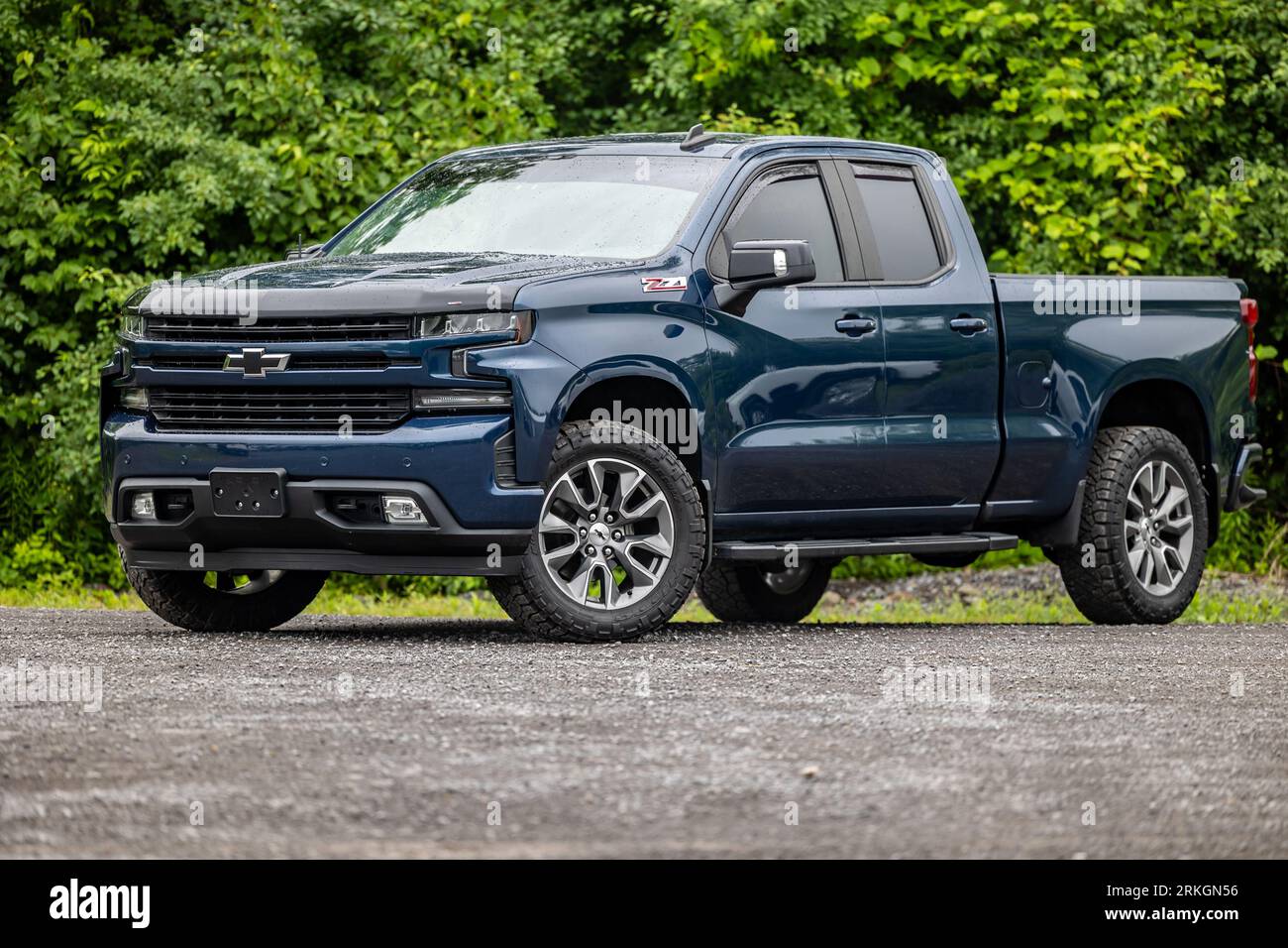 A blue Chevrolet Silverado pickup truck parked in a lush green grassy ...