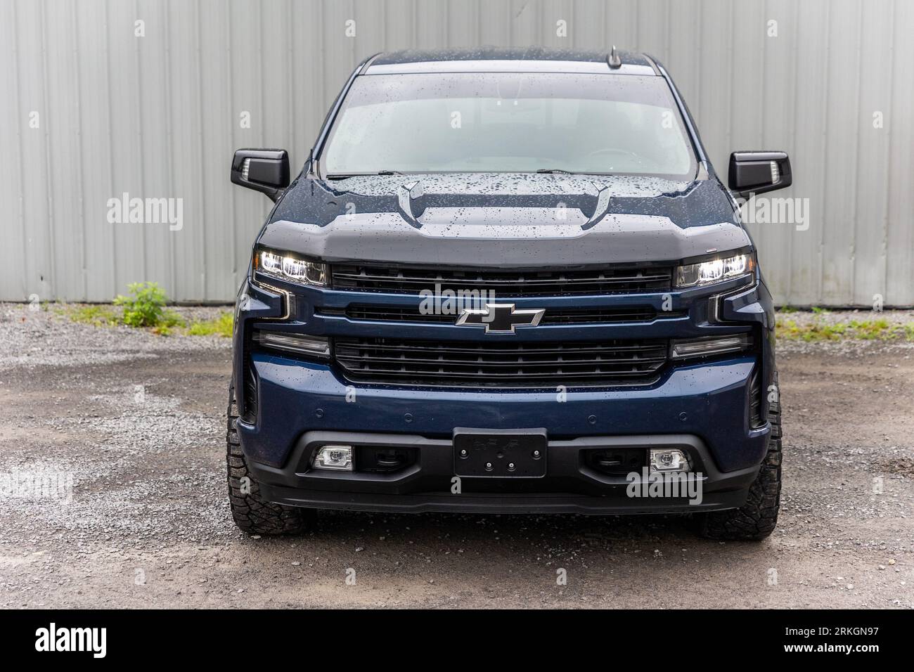 A blue Chevrolet Silverado pickup truck parked in a lush green grassy ...