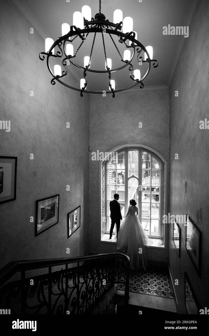 Two adult married partners standing together in a stairwell, looking ...