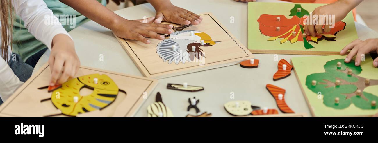 partial view of kids playing with didactic materials during lesson in ...