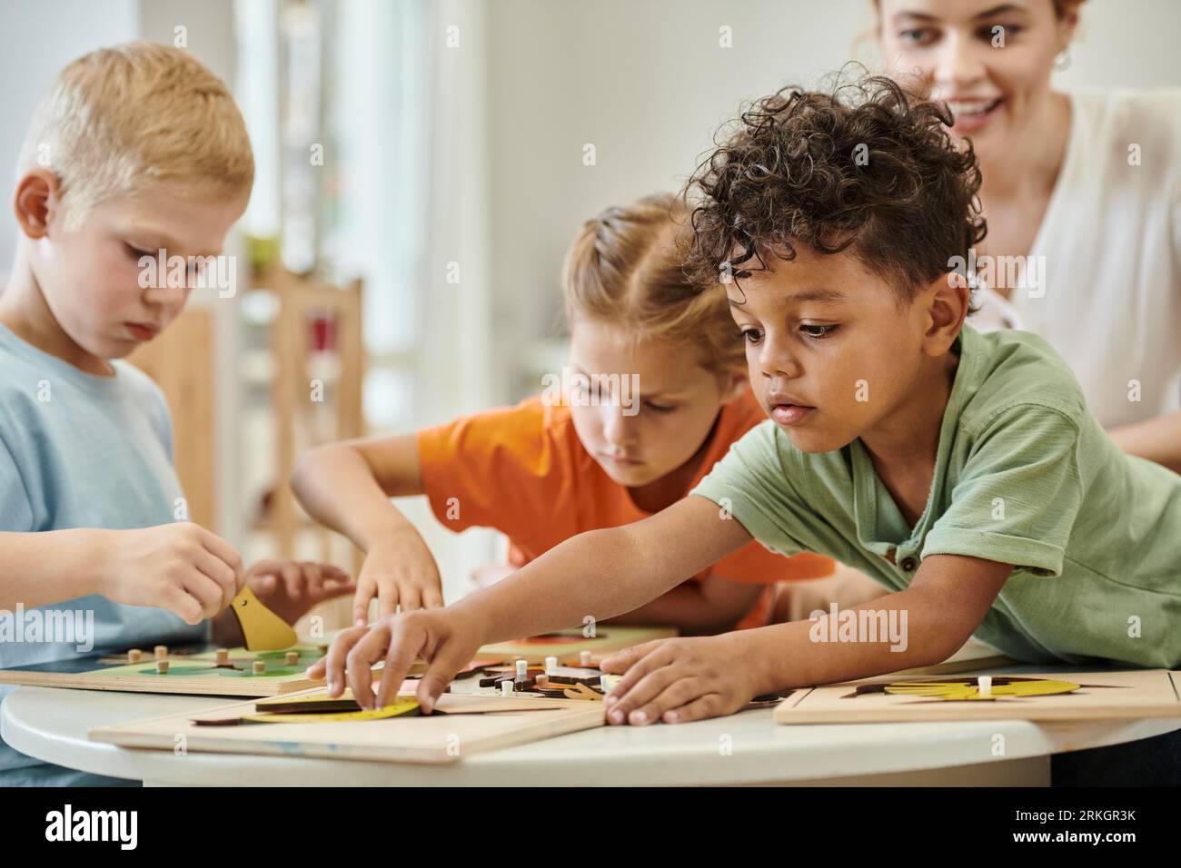 african american kid playing with didactic material near children and ...