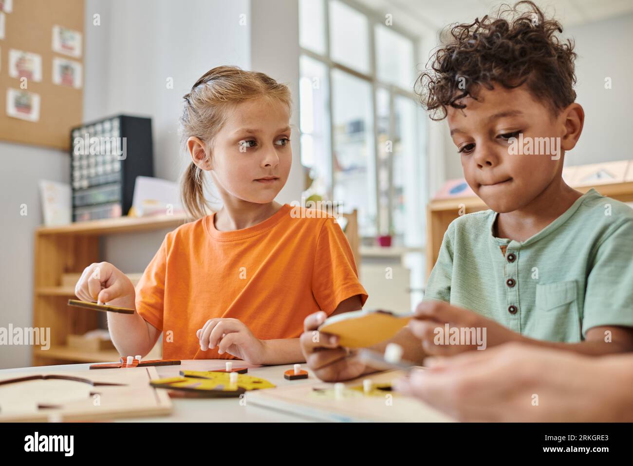 interracial children playing with didactic montessori material in ...