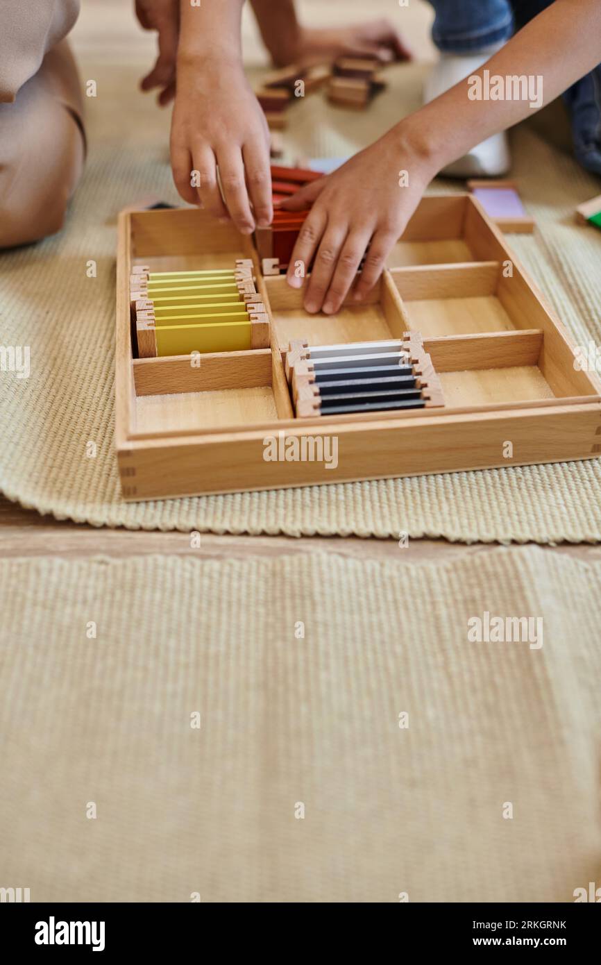 montessori school concept, girl playing color matching game near female ...