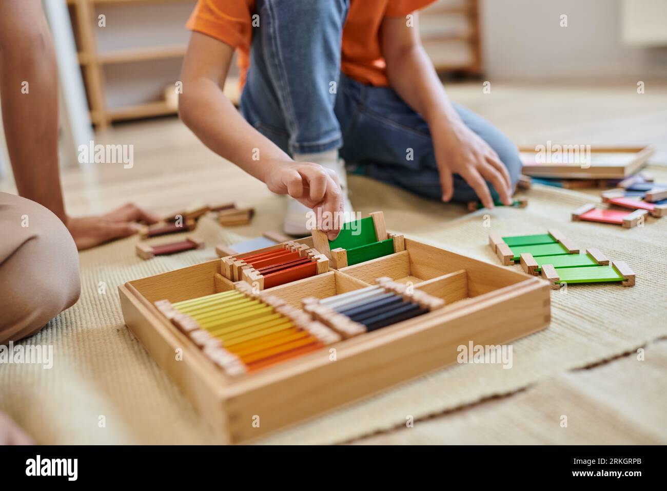 montessori school concept, cropped view of girl playing color matching ...