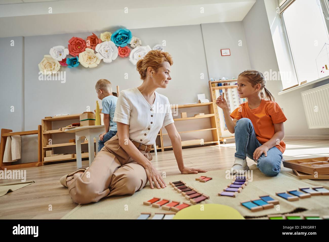 color matching game, girl showing piece of montessori material to happy ...
