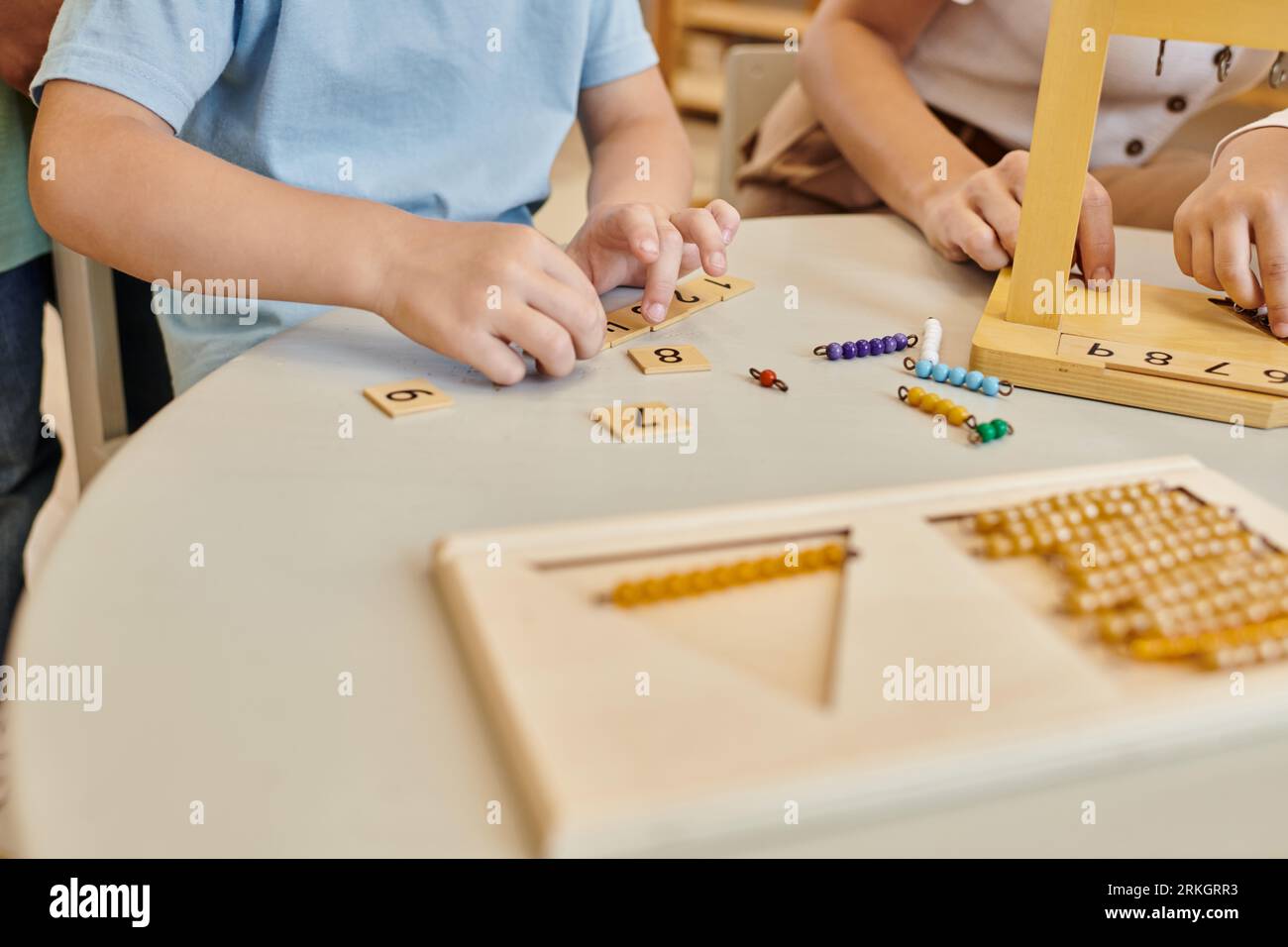 montessori school, cropped view of kids playing educational game, math ...