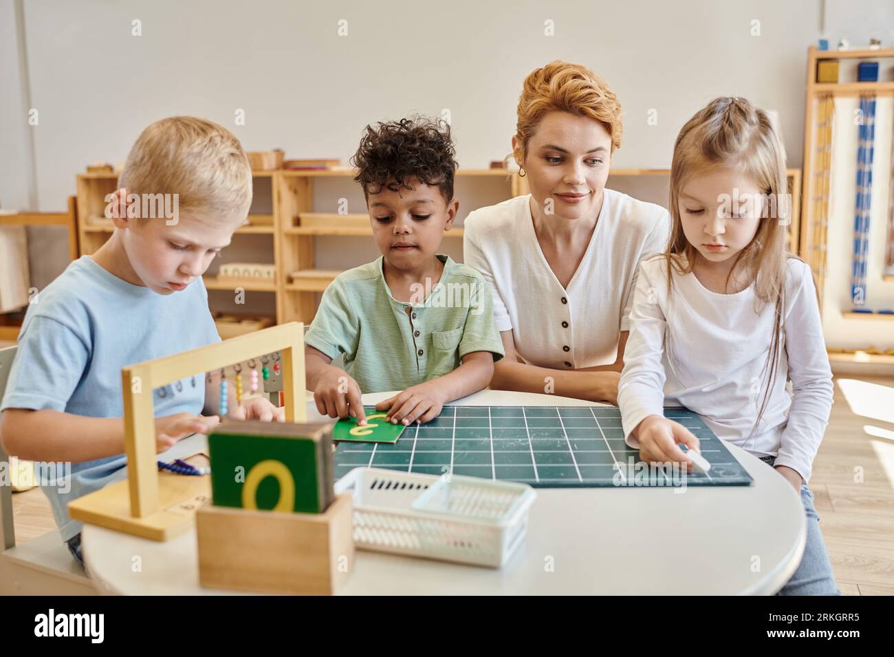 montessori school concept, multicultural children, girl writing on ...