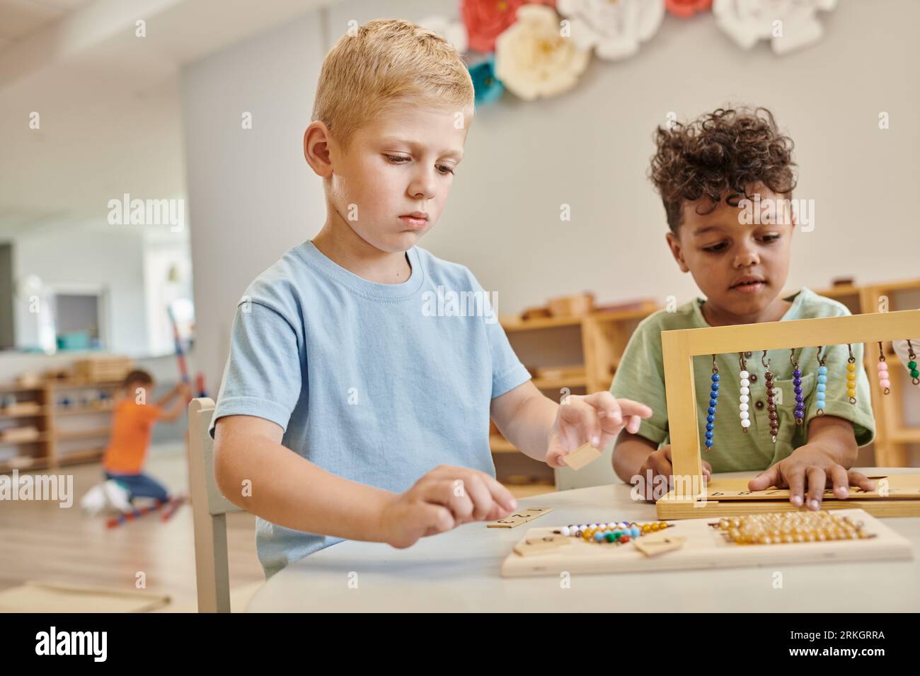 montessori school concept, multicultural boys playing with color bead ...