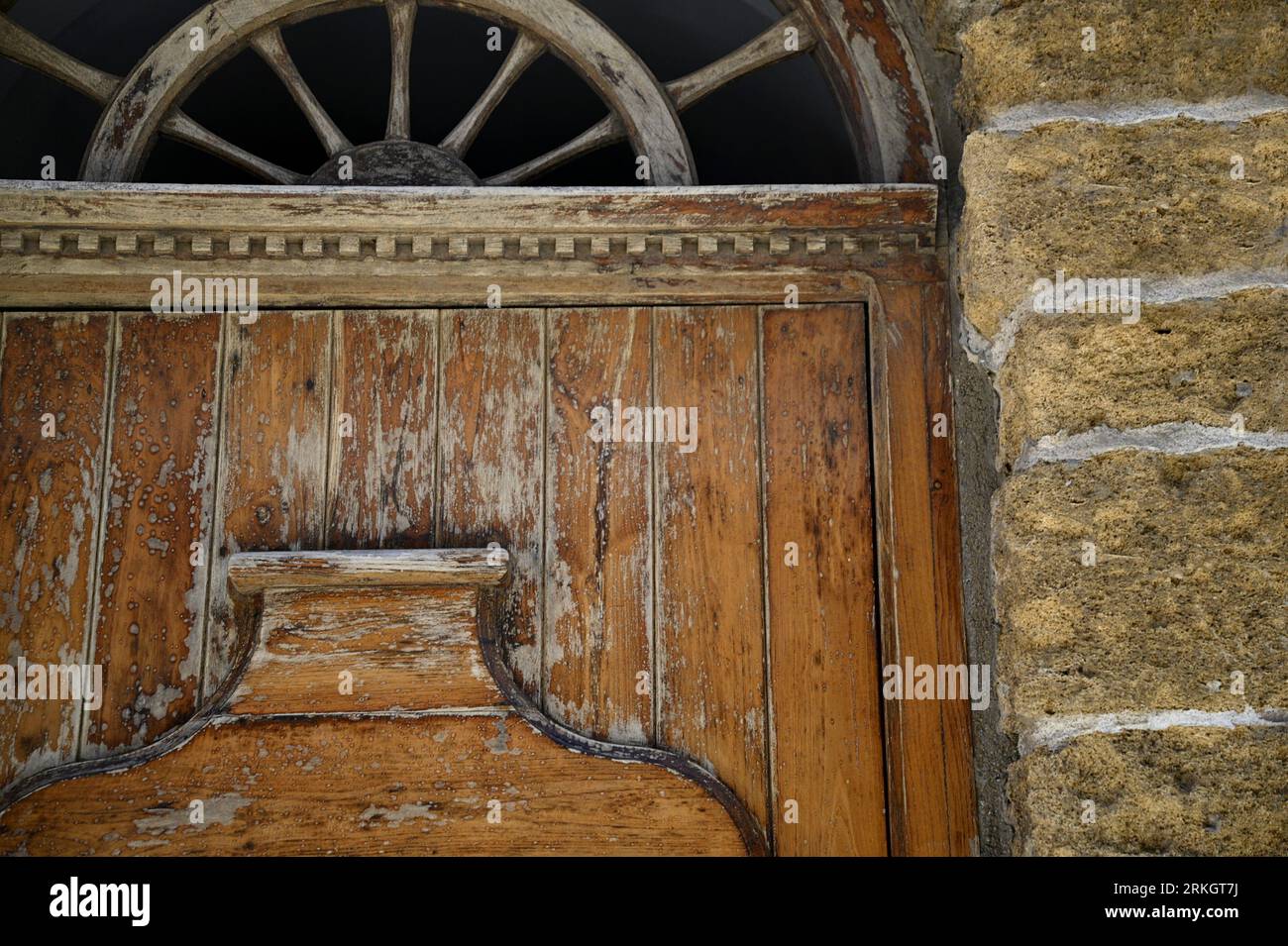 Antique wooden arched portal on a handcrafted stone wall in Cefalù ...