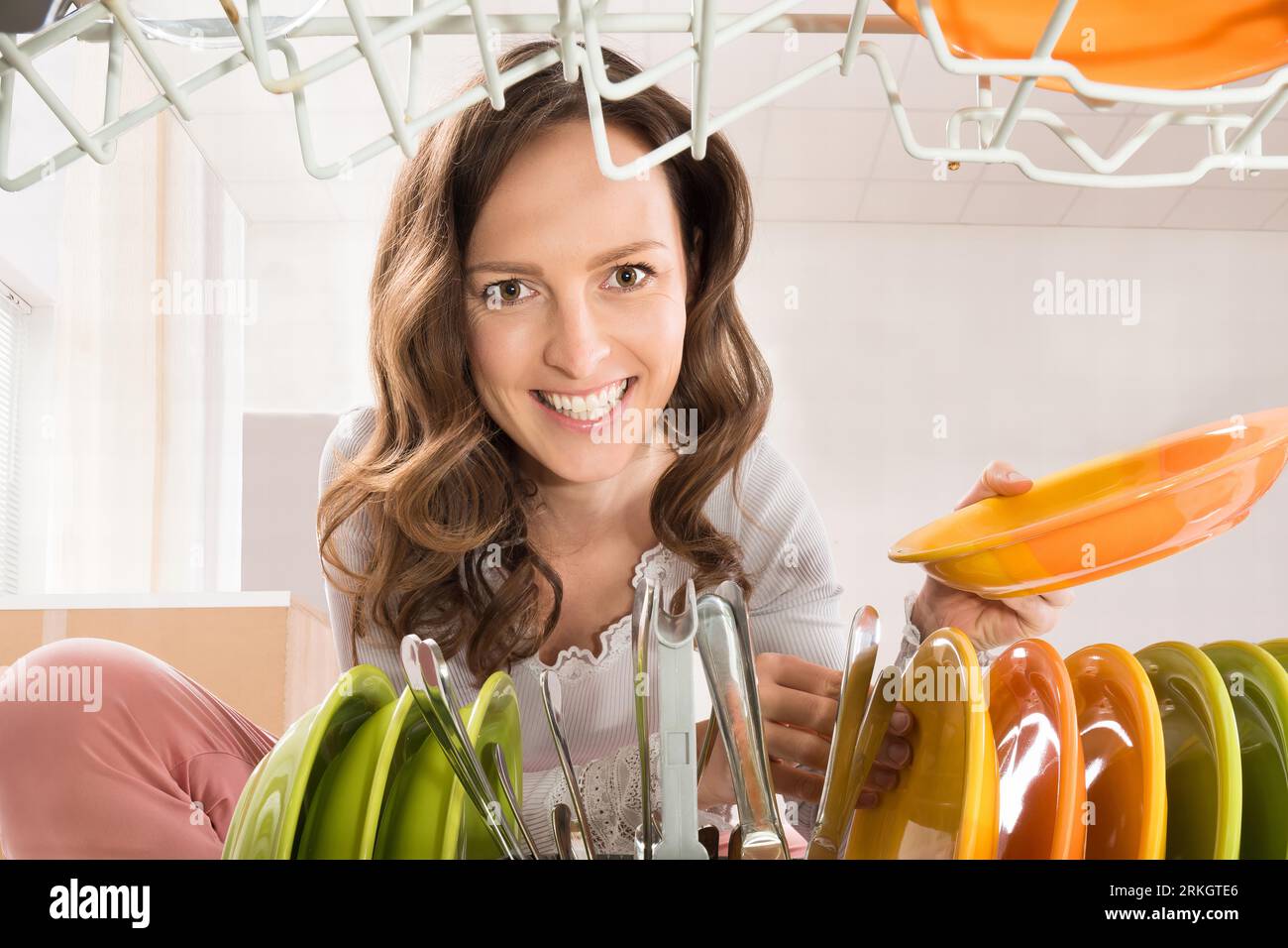 Happy Woman Removing Plate View From Inside The Dishwasher Stock Photo ...