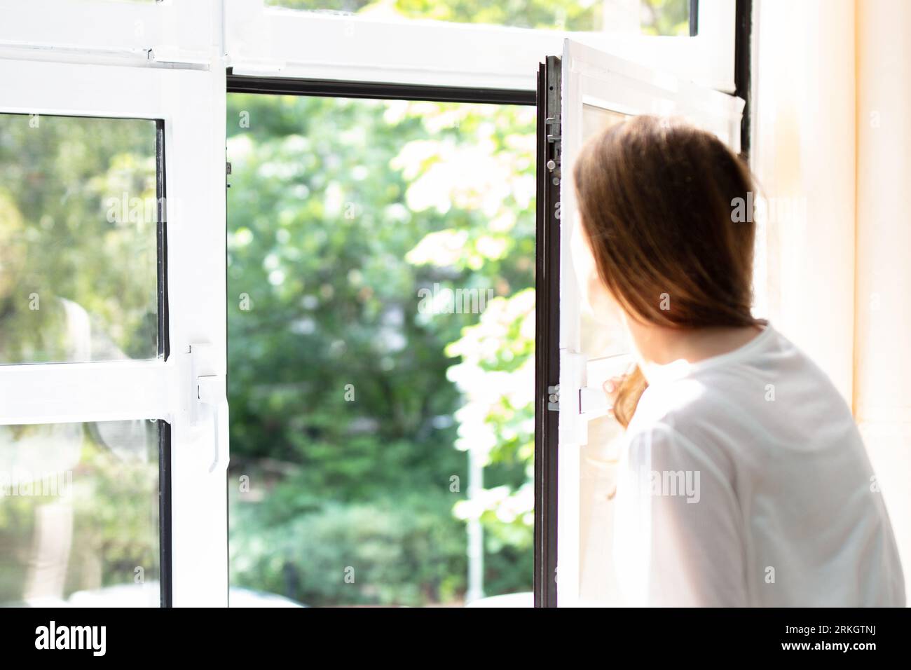 Side View Of A Businesswoman Looking Out Of A Window From An Office ...