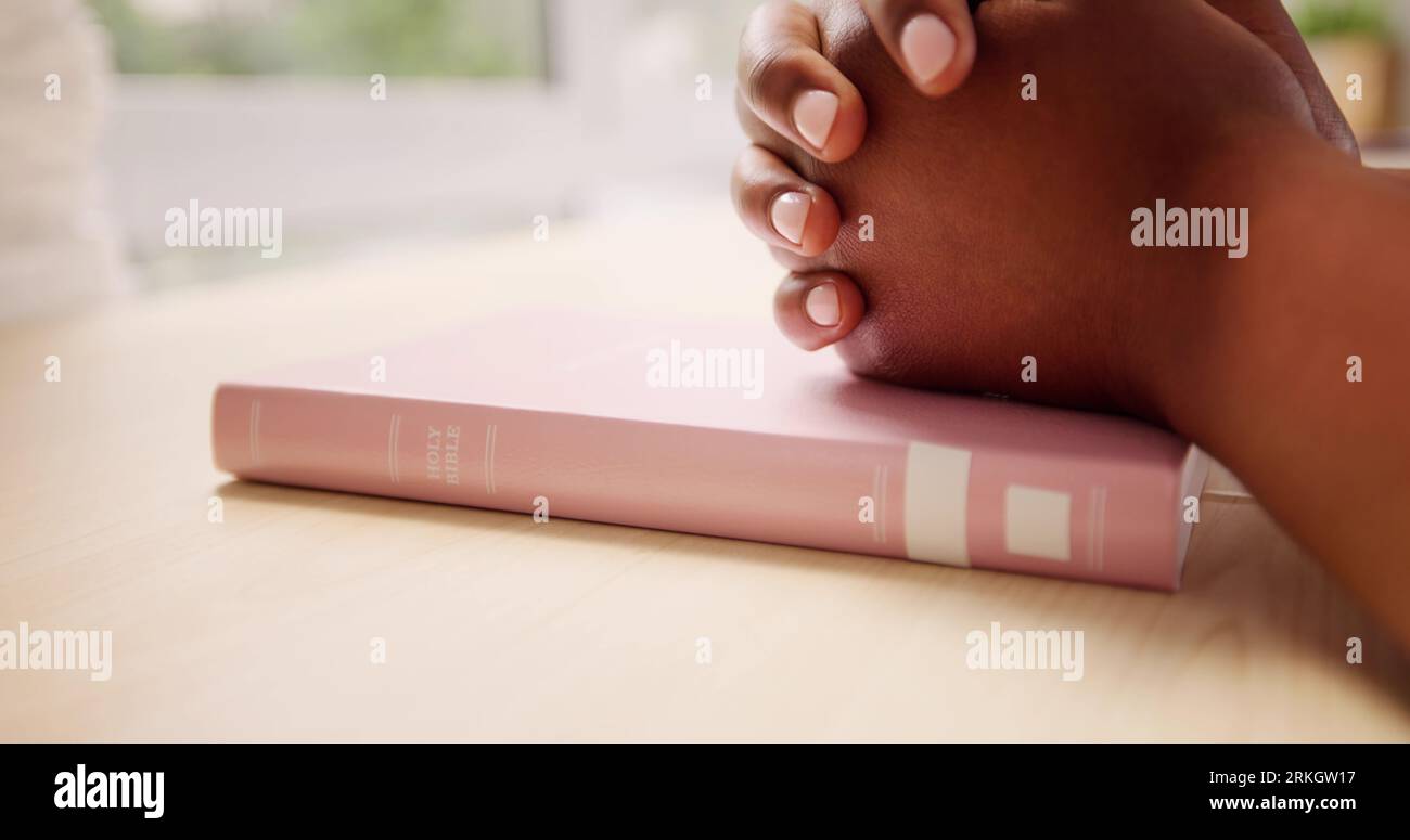 African American Black Christian. Bible In Prayer Hands Stock Photo - Alamy