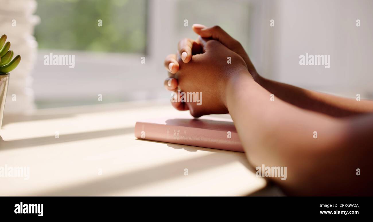 African American Black Christian. Bible In Prayer Hands Stock Photo - Alamy