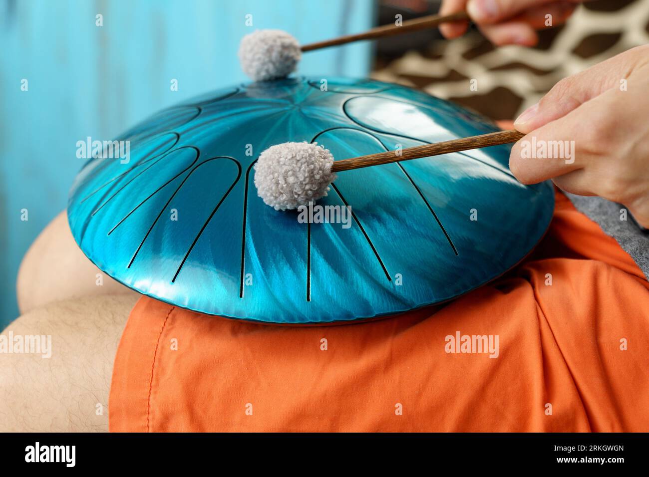 Glucophone and drum sticks on the lap man playing on instrument, drum ...