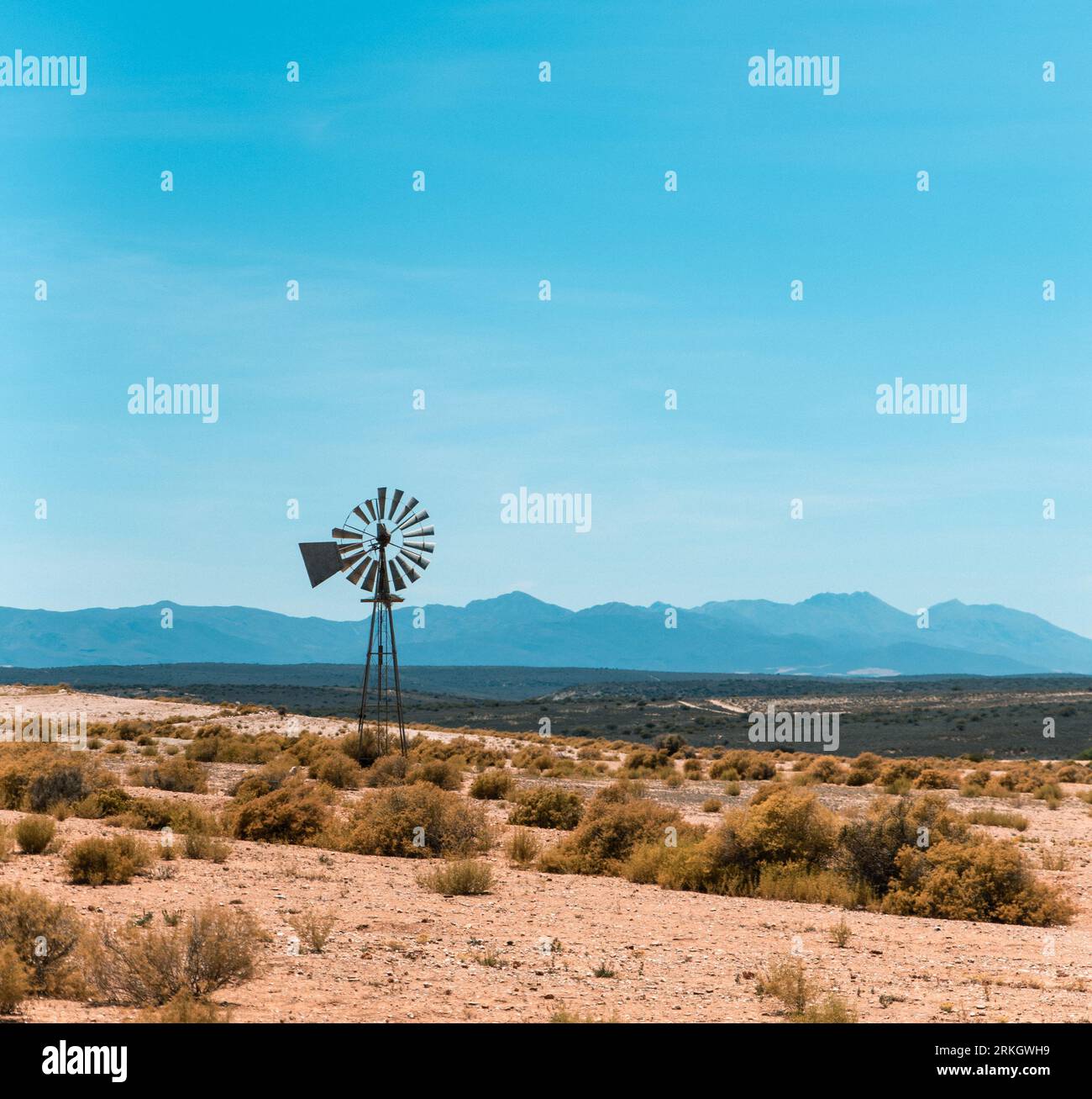 A scenic view of an old windmill in a desert in Karoo in the Western ...