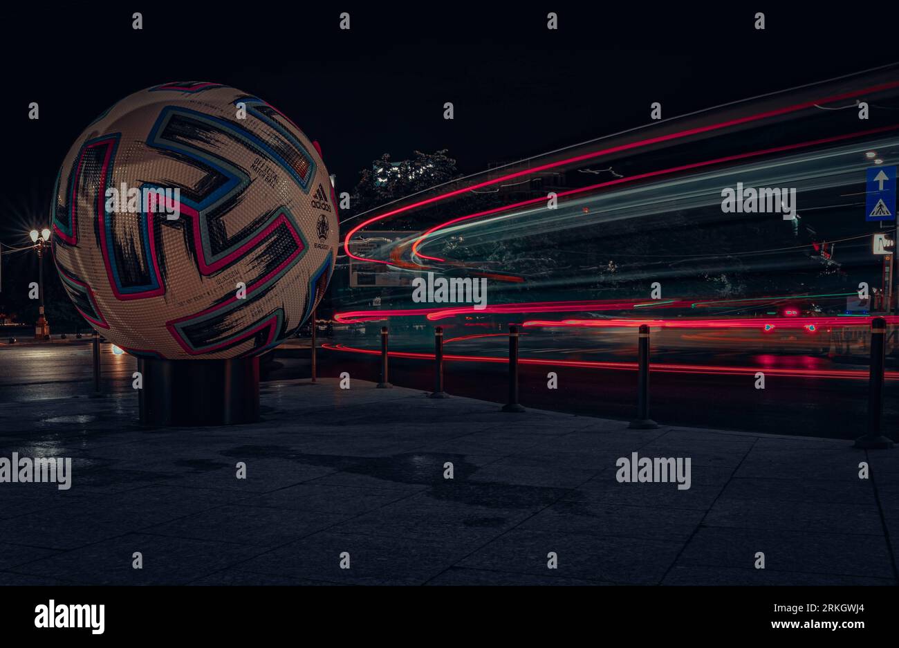 A vibrant illuminated street ball sitting atop a street in a night-time ...