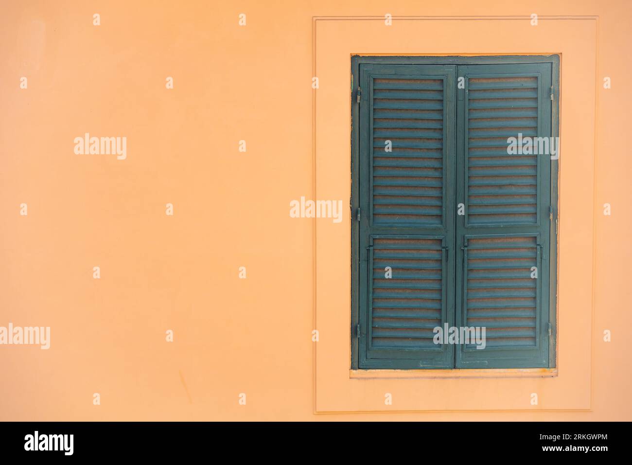 Yellow stucco wall with green shutters. Taken in Italy. Symmetry with ...