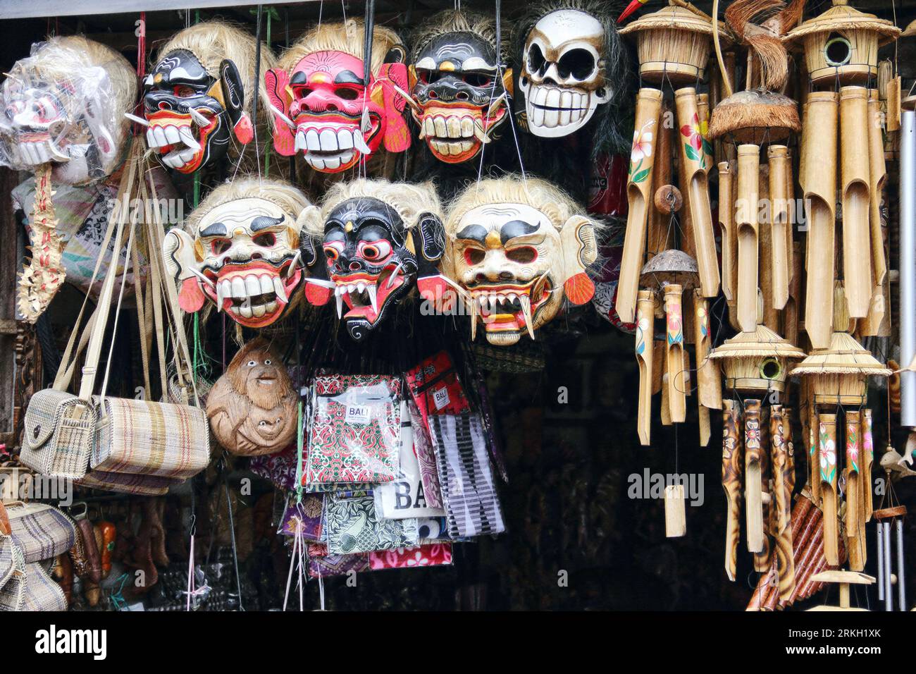 A variety of decorative masks made of wood hanging from the ceiling at ...