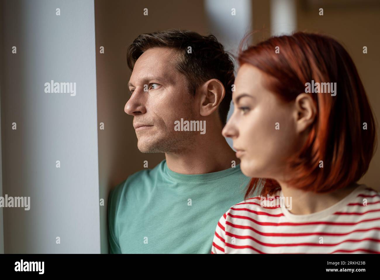 Pensive middle aged german man and woman looking out the window ...