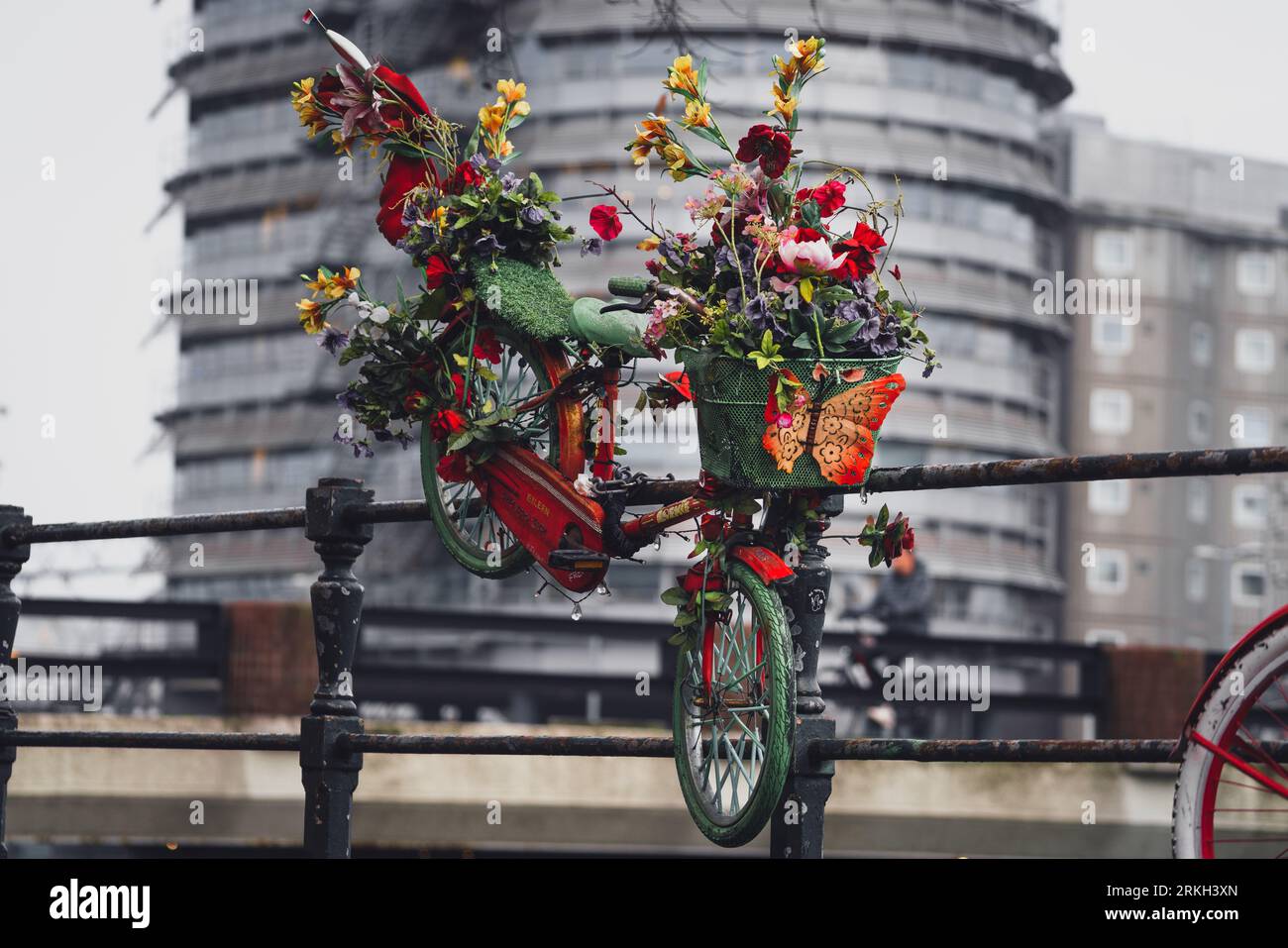 A colourful flower bike hung as a decoration on railings on the street ...