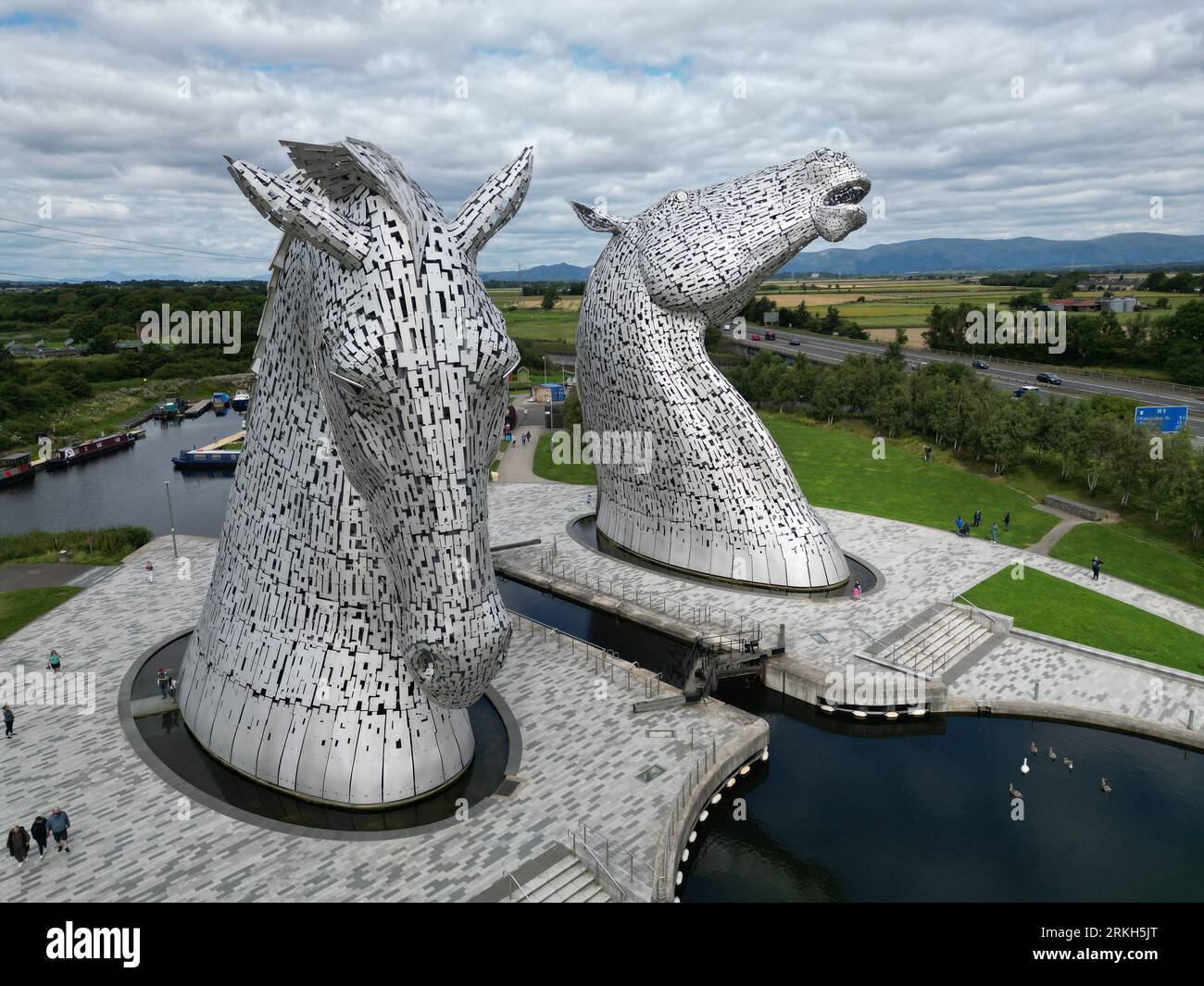 A pair of imposing full-scale statues of horses crafted from metal ...