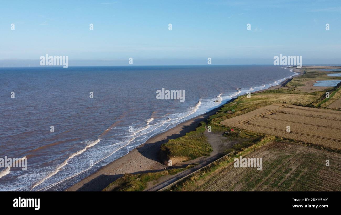 A tranquil scene of the ocean shoreline, featuring an empty beach and ...