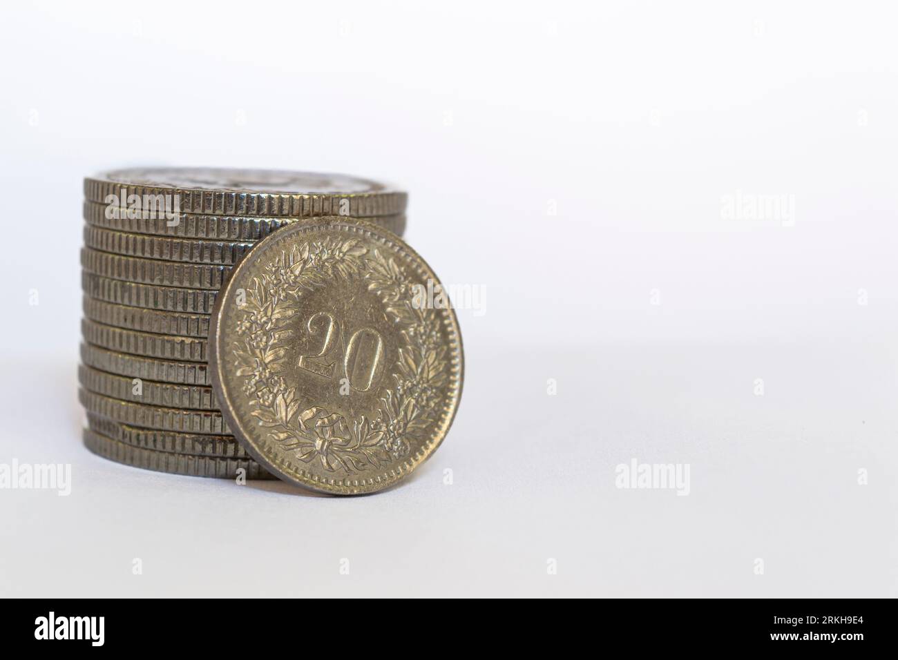 A close-up image of a stack of Swiss franc coins with a white ...