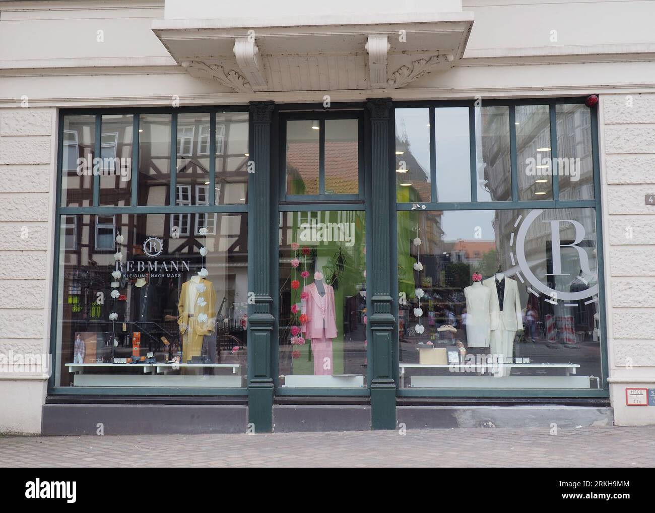 A tailor's shop window, with a reflection of half-timbered houses in ...