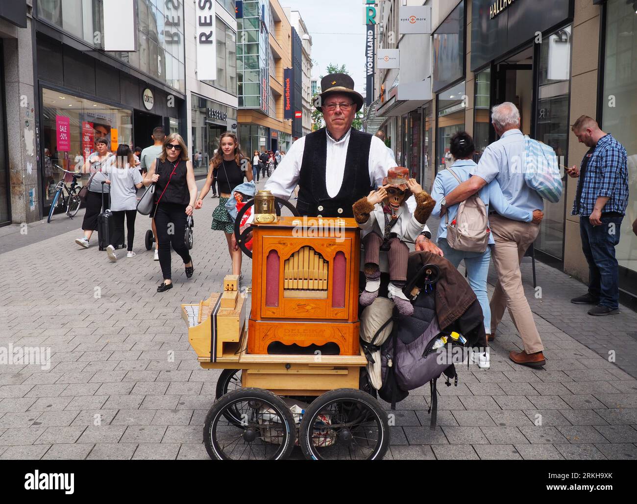 A barrel organ player wearing a traditional vest in the bustling ...