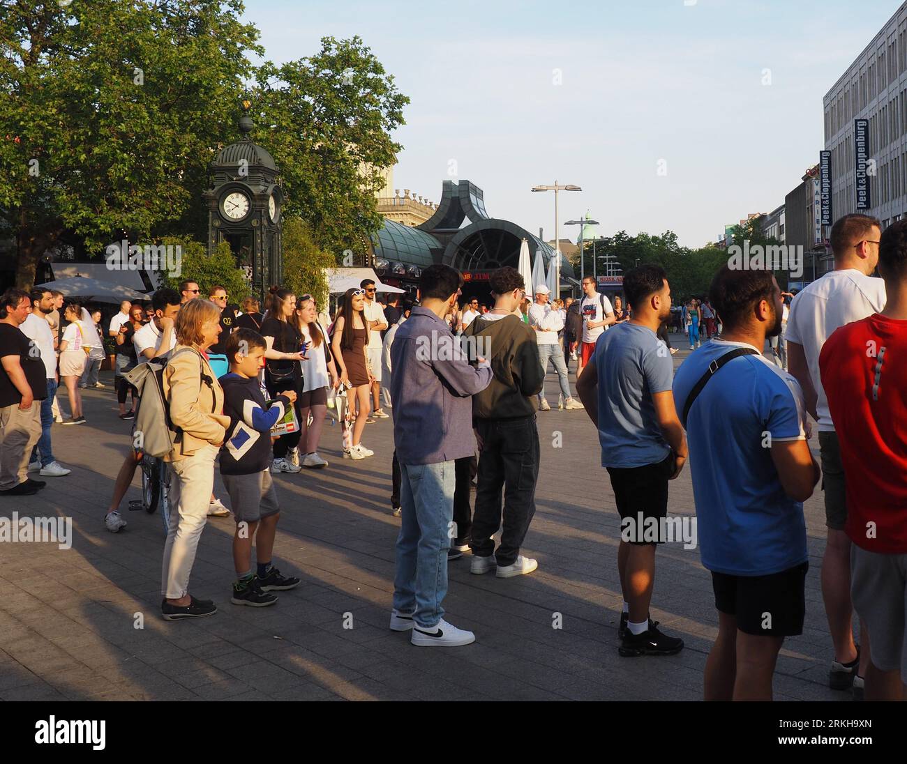A diverse group of people crowded together on a busy city street ...