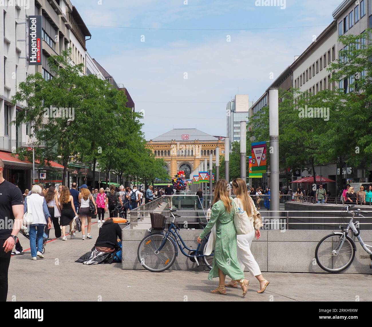 A city street with pedestrians walking down the sidewalk surrounded by ...