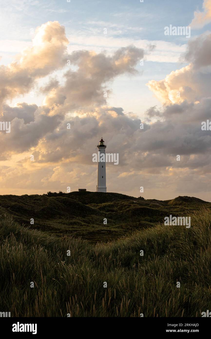 An idyllic scene of a majestic lighthouse perched atop a grassy hill ...