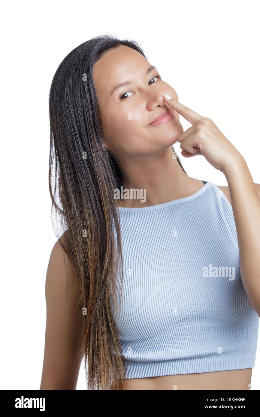 Asian Woman pointing at her nose isolated on a white background with ...