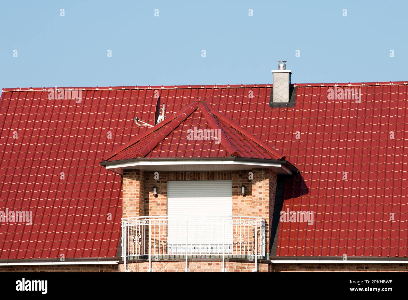 A red-tiled roof on a countryside house with protective railings ...