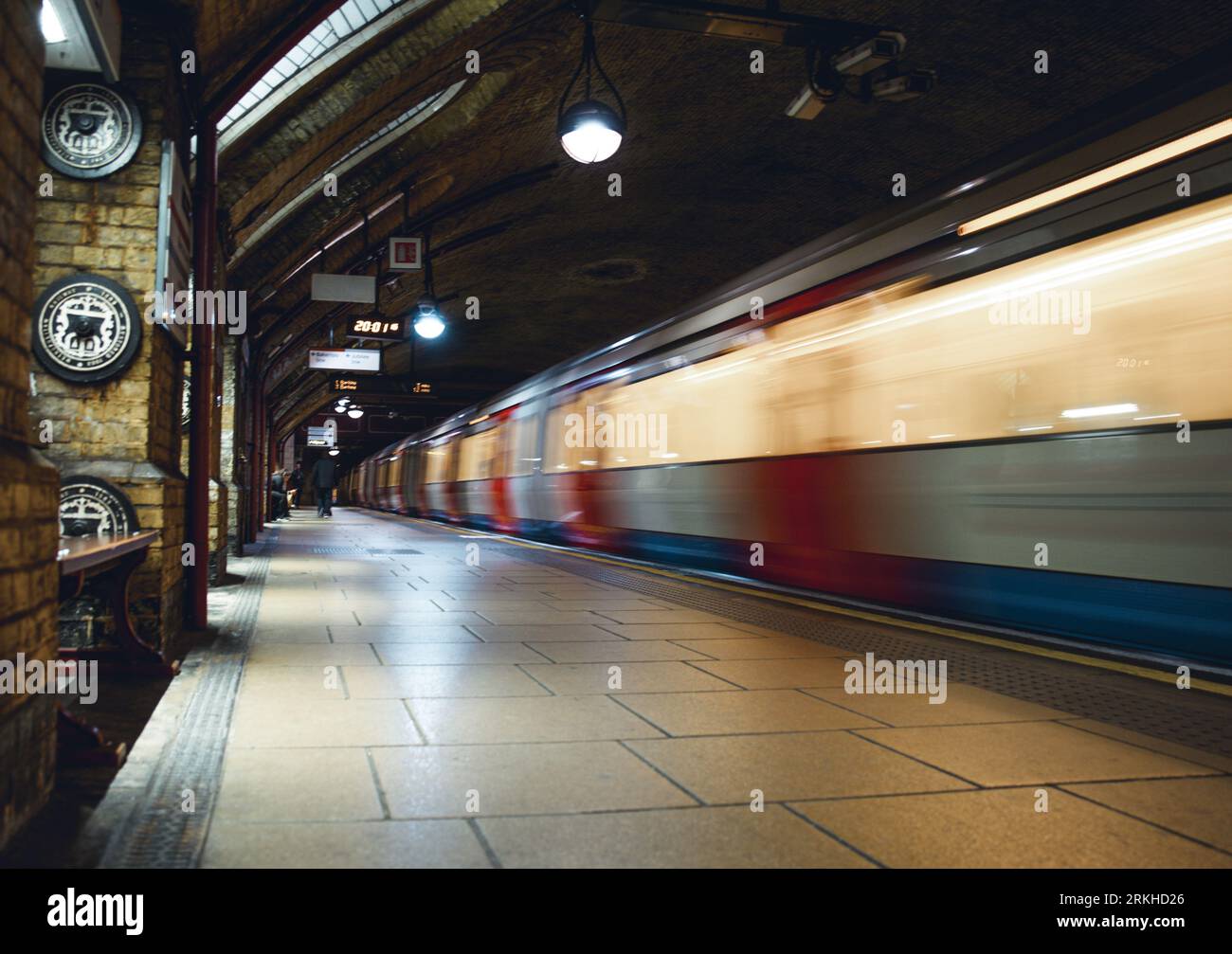 An urban subway train illuminated by bright lights passing through a ...